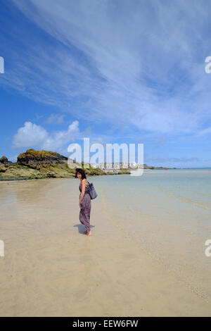 Woman walking along the cool waters of a stream in Loamhole Dingle, Coalbrookdale, England ...
