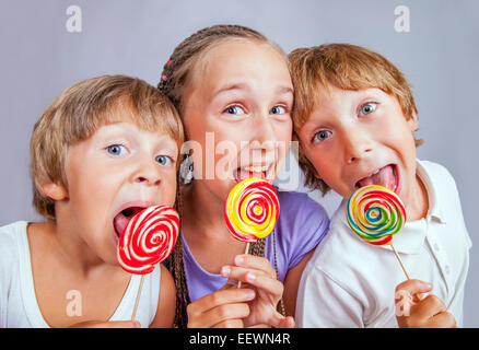 Funny child with candy lollipop, happy little girl eating big sugar ...