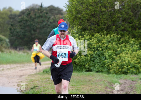 Runners in a coastal cross-country race on a sandy unmade road Stock ...