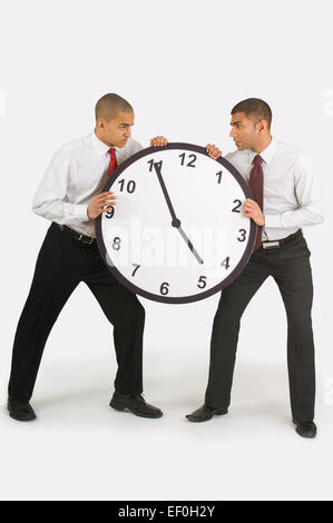 Businessmen fighting over a clock Stock Photo - Alamy