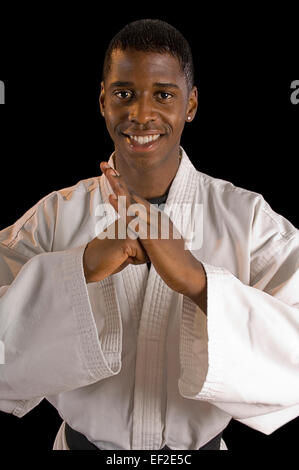 Studio shot of happy Japanese man smiling while talking on mobile phone ...