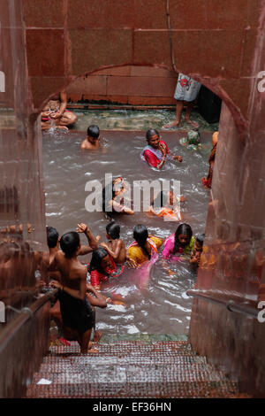 Hindu pilgrims bathing in hot springs below the Badrinath temple, India ...