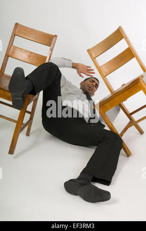 Man falling off a chair Stock Photo - Alamy
