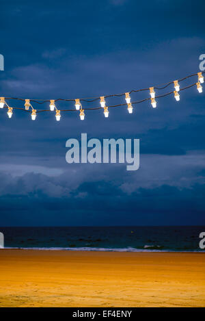 row of light bulbs on the beach at sunset Stock Photo - Alamy