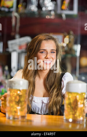 smiling young barmaid serving a pint in a traditional british pub the ...