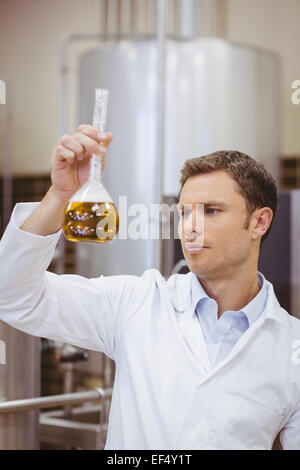 Concentrated scientist looking at beaker Stock Photo - Alamy