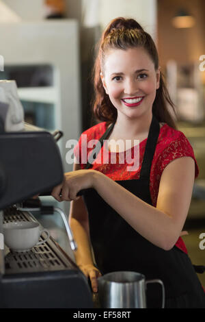 Portrait of attractive cheerful girl barista holding in hands bringing ...
