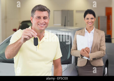 Smiling customer showing his new car key Stock Photo - Alamy
