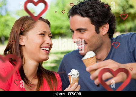 Two friends laughing while holding ice cream Stock Photo - Alamy
