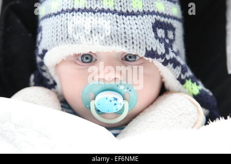 Baby boy bundle up for winter with a pacifier Stock Photo - Alamy