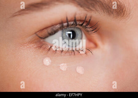 Young beautiful woman applying concealer on white background Stock ...