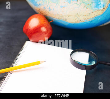 Old blue book with a magnifying glass and pen on top, on a wooden desk ...