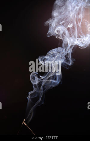 Curling smoke from two extinguished candles on black background Stock ...