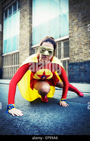 front view of a woman crouching and looking at the ground on white ...