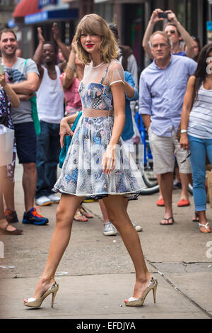 Taylor Swift shows off her midriff in a two-piece textured dress as ...