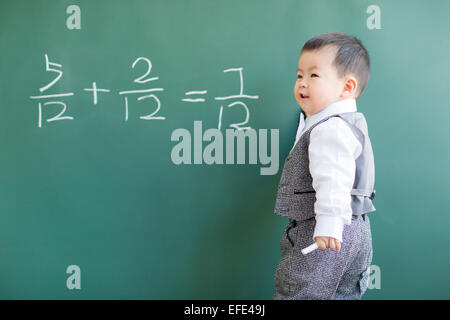 Cute baby doing mathematics on blackboard Stock Photo - Alamy