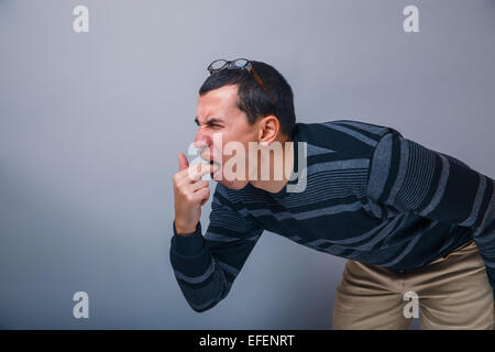 male of European appearance brunette put his fingers in his mout Stock ...
