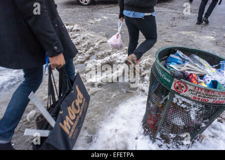 Pedestrians slog through puddles of slush and snow at street crossings ...