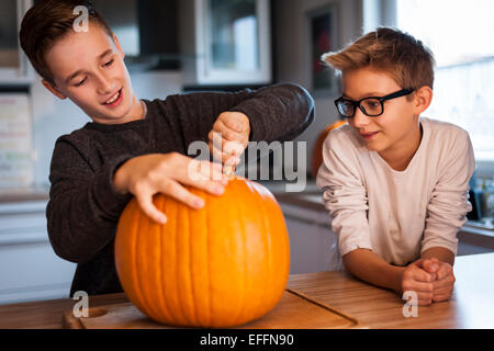 Two boys preparing a pumpkin for Halloween lantern Stock Photo - Alamy