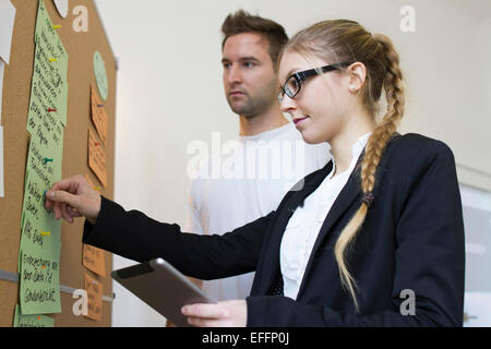 Two office workers at pinboard Stock Photo - Alamy