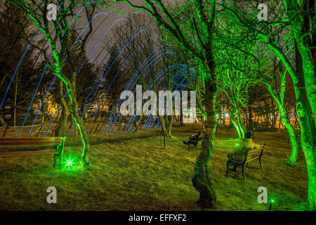 Festival of lights in city park, pond fire along coast with people ...