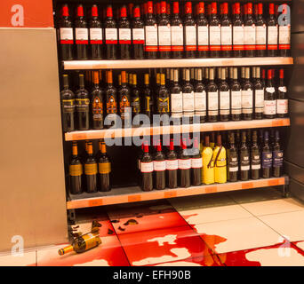 Broken bottle of spilt red wine on supermarket floor Stock Photo - Alamy