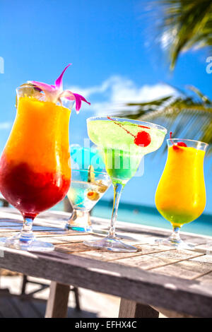 Glasses of cocktails on table on blue sea background Stock Photo - Alamy