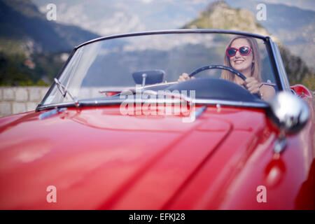 Young woman driving a vintage classic sports car in the South of France ...