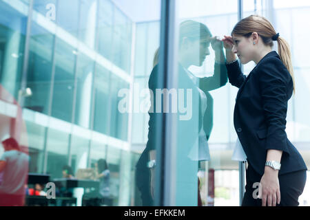 Businesswoman peering through glass window Stock Photo - Alamy