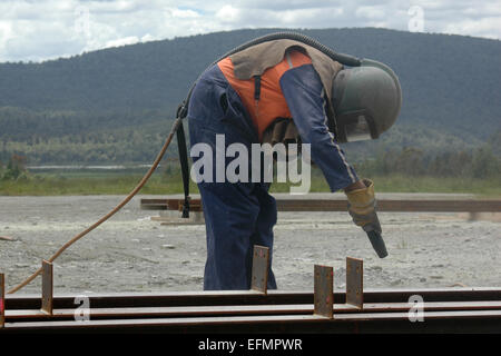 tradesman sandblasting beams for building project Stock Photo - Alamy