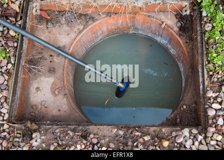 Clearing a blocked house drain with drain rods Stock Photo - Alamy
