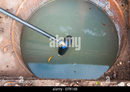 Clearing a blocked house drain with drain rods Stock Photo - Alamy