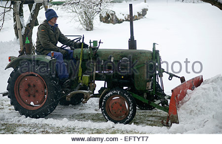 Man driving a small tractor ploughing or plowing field on specialist ...