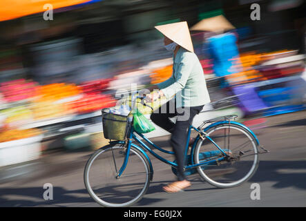 Woman cycling past market, Ben Tre, Mekong Delta, Vietnam Stock Photo ...