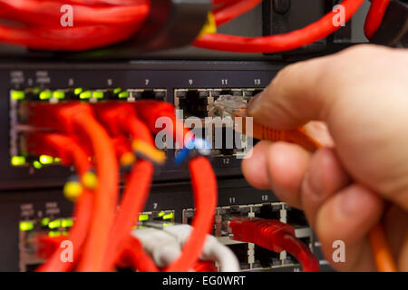 Close up of a IT consultant inserting / connecting a network cable into ...