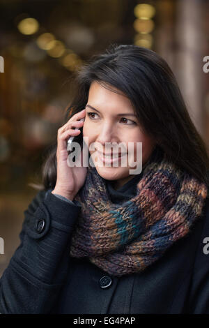 Pretty brunette talking on the phone is surprised by something Stock ...
