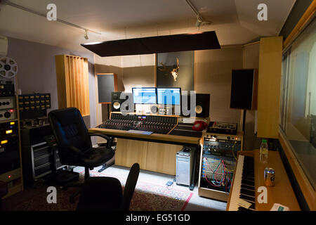 Inside a music recording studio with mixing desk and recording ...