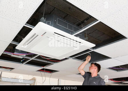 A ceiling-mounted air conditioning unit is installed in a modern room ...