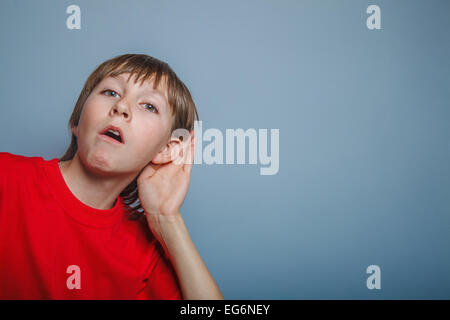 European appearance boy overhears a decade, interest, ear on gray ...