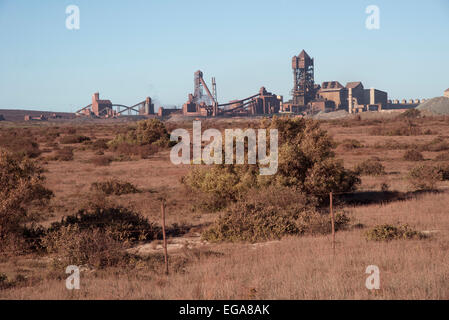 Steelworks and reddish dust of iron ore covering the landscape at ...
