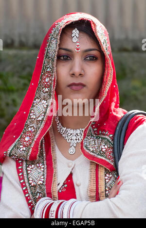 A Sikh woman in traditional clothing prays during the procession for ...