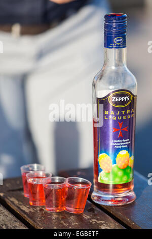 Bottle of Malta's Zeppis Bajtra prickly pear liqueur and shot glasses ...