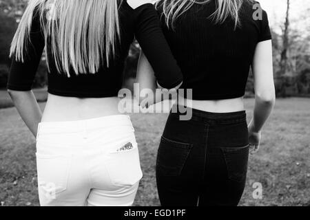 Girls linking arms and walking Stock Photo - Alamy