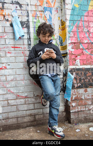 School child sending message texting using smarpthone over yellow ...