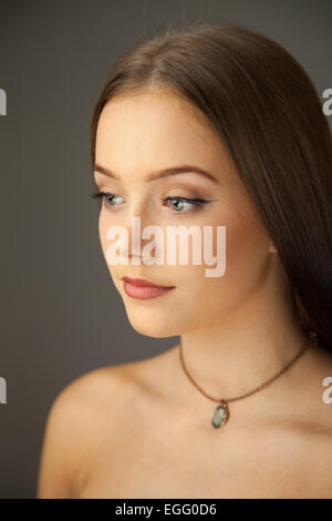 Woman looking left and down eyes closed bare arms crossed head on ...