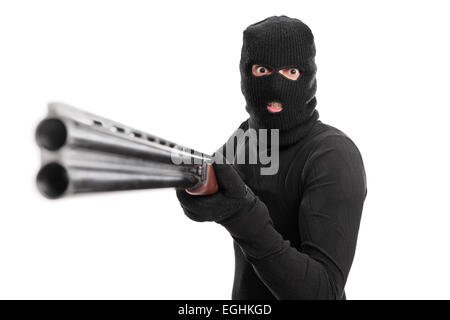 Masked man pointing gun on black background Stock Photo - Alamy