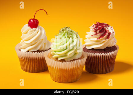 three cupcakes isolated on orange background Stock Photo - Alamy