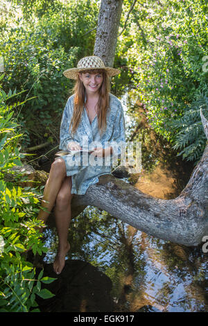 Smiling beautiful girl with a book, reading with thoughtful smirk ...