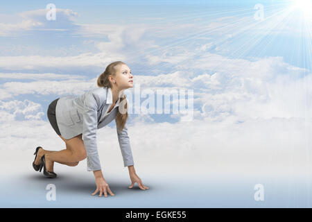 Businesswoman standing in running start pose, smiling, side view ...