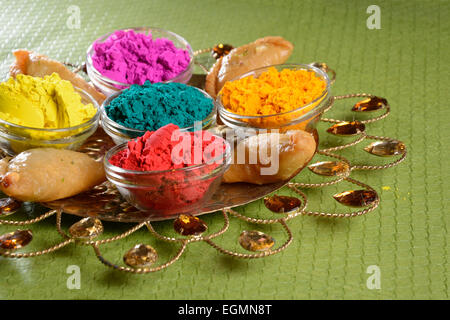 Gujia is a cuisine of India surrounded by colorful gulaal in the bowls ...